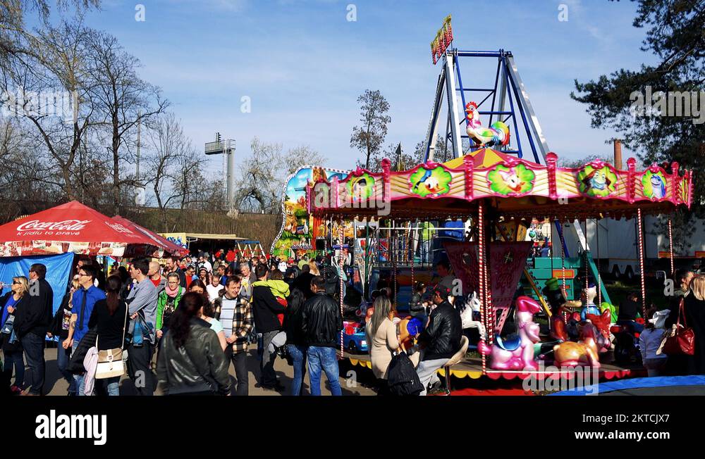 People walk and wait in front of carousel in funfair Stock Video ...