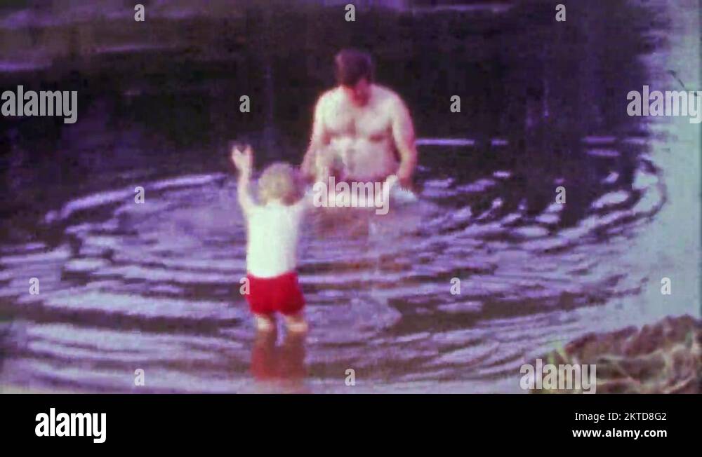 1967: Fun hairy soft dad playing with kids in dirty pond water Stock ...