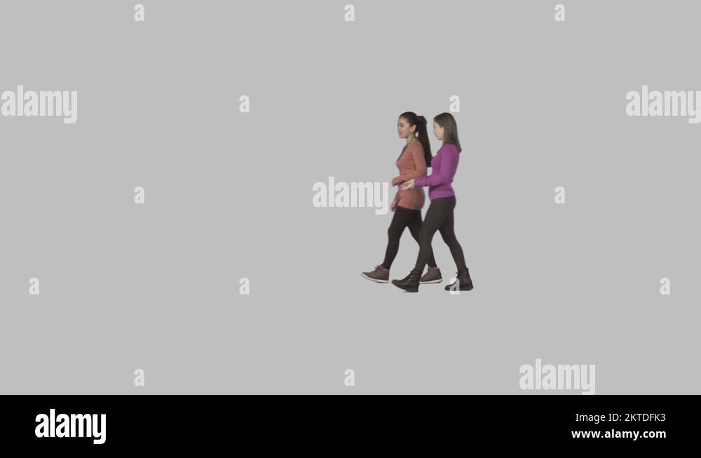 Two girls in casual clothes are walking and talking. Transparent ...