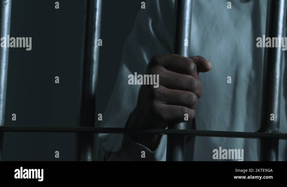 Modern Prison or Jail Scene - Pan across hands on bars Stock Video ...