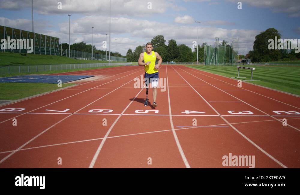 4K Portrait disabled athlete with prosthetic leg crossing finish line ...