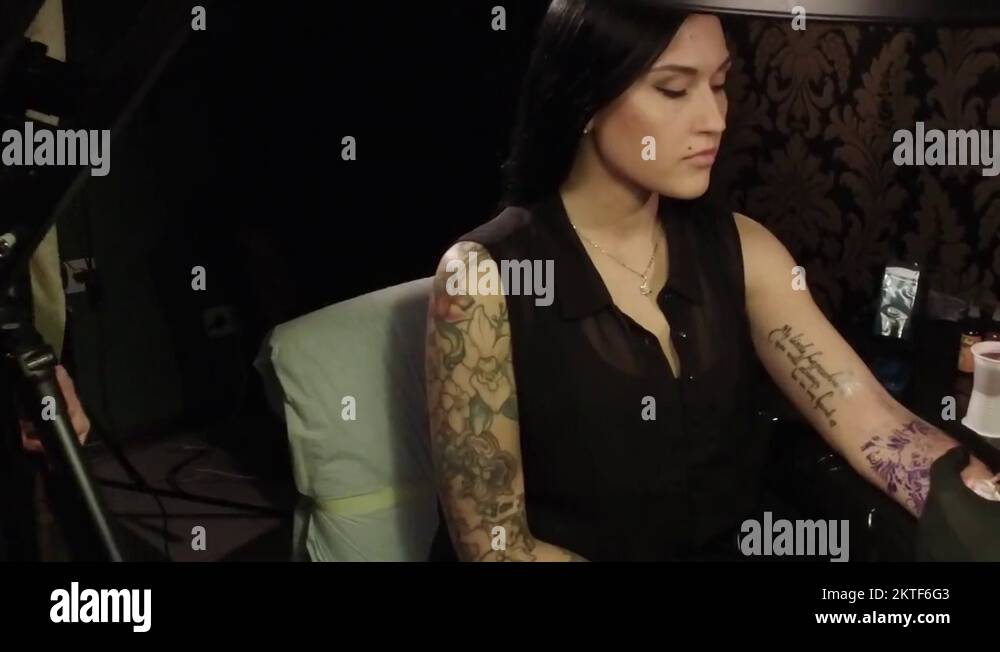 Professional tattoo artist makes a tattoo on a young girl's hand in ...