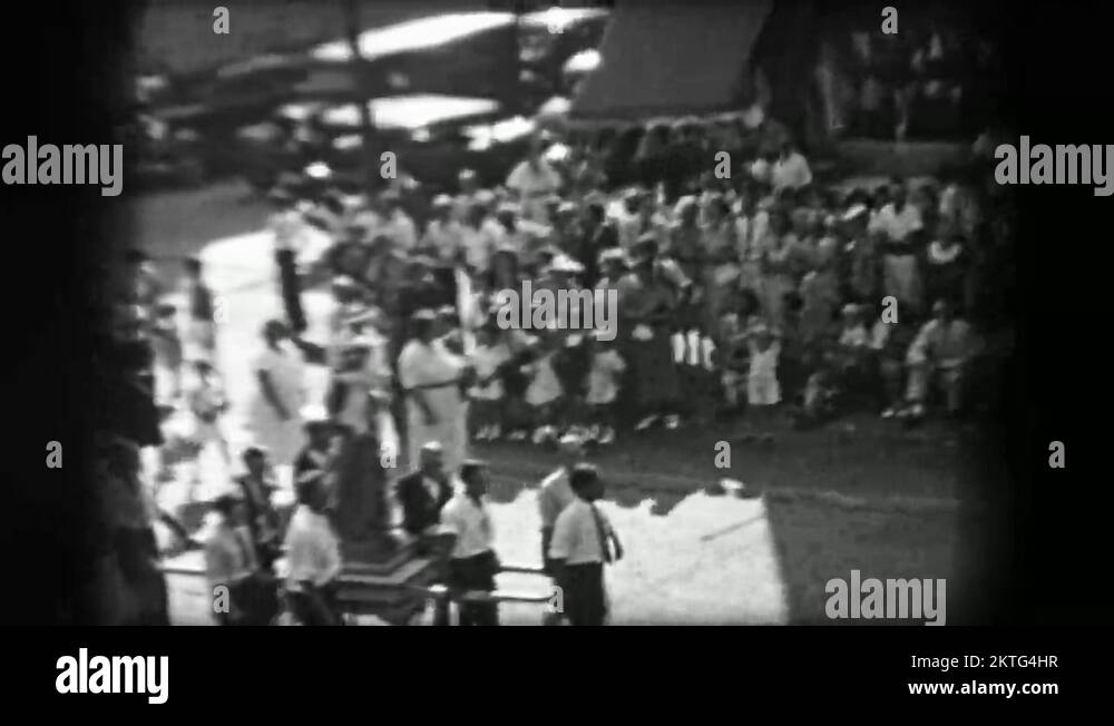 1938: Parade marching carrying large statue down middle of street ...