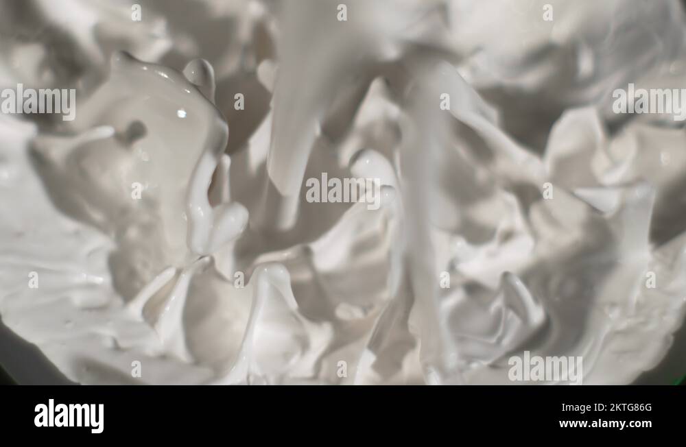 White fluid pulses on top of a speaker, the fluid creates patterns and ...