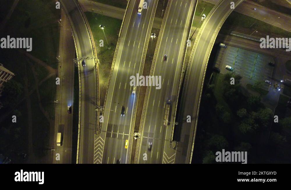 Cars and trucks driving on lanes of highway at night time. Top view ...