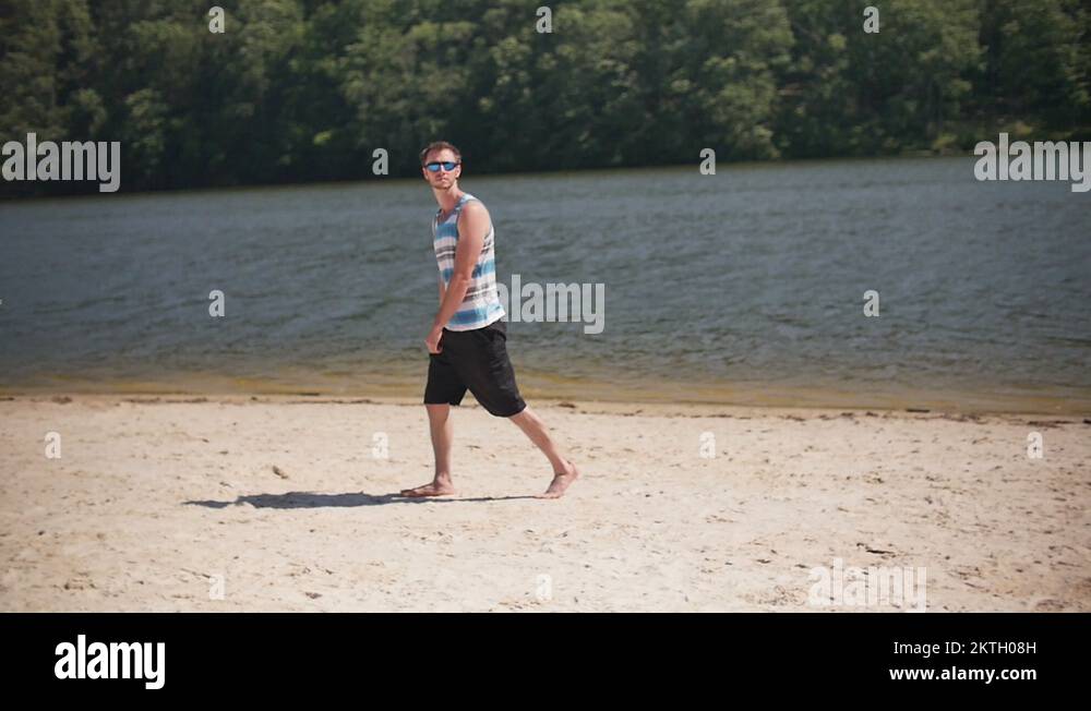 Running to Catch Football on Beach at Lake a Young Man Slow Motion ...