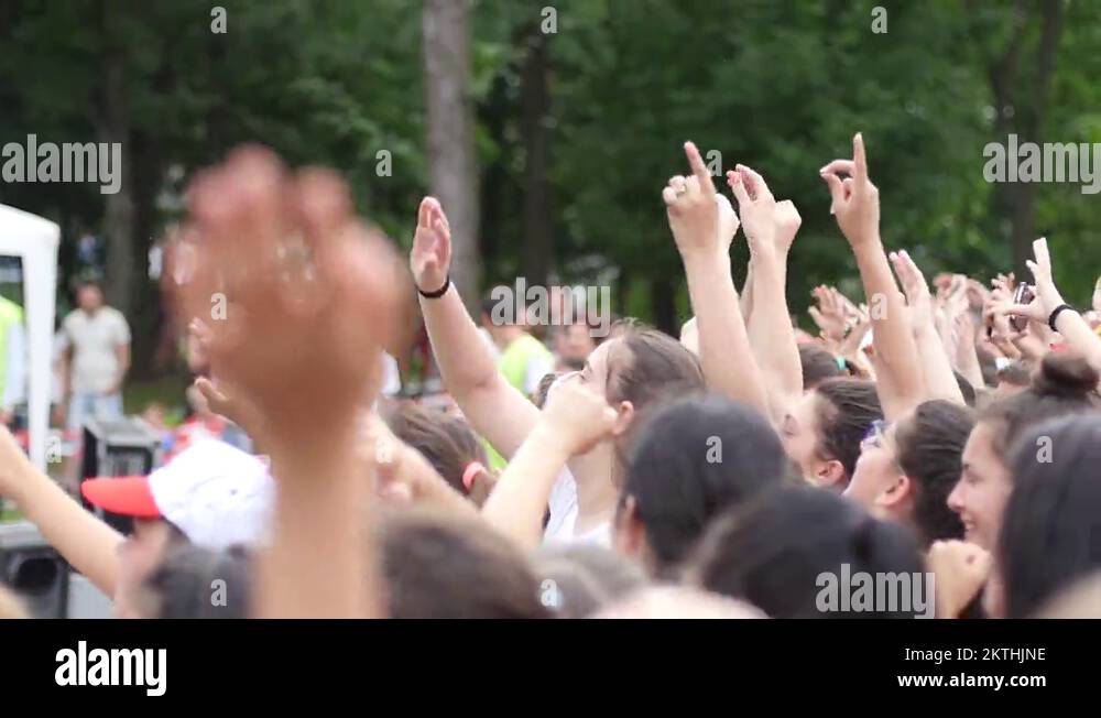 Young spectators fans crowd people cheering sway hands in air by a ...