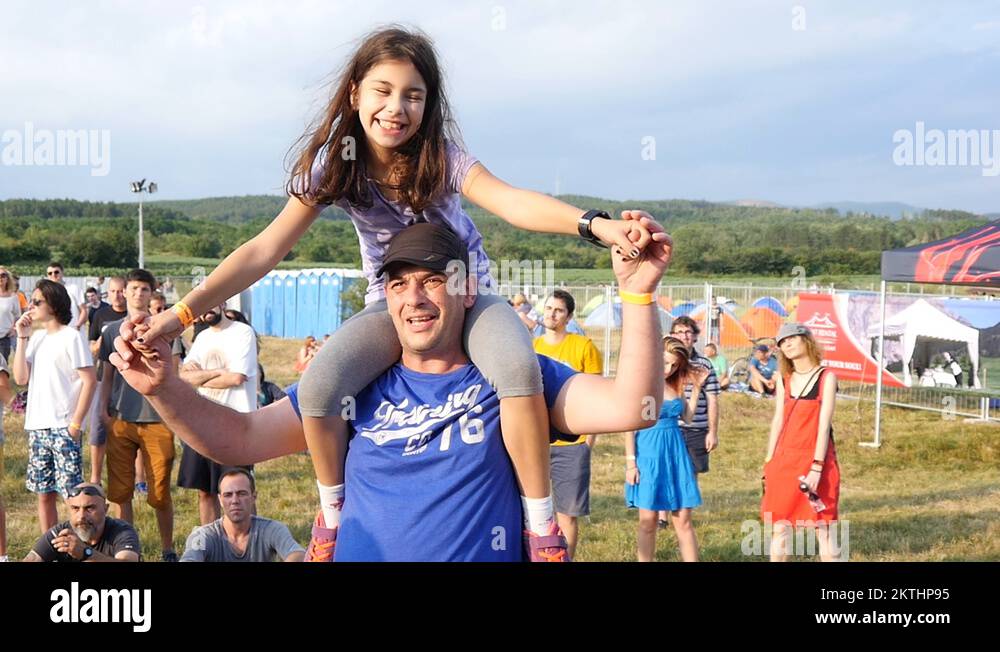 Pretty cute little kid girl sit on father shoulders enjoying open air ...
