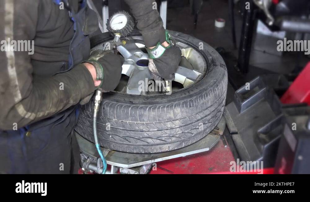 dirty worker hands inflate tire air wit compressor on mounting machine ...