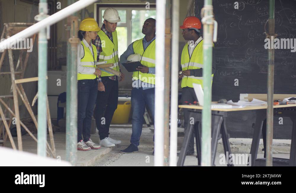 4K Construction team working together on site with foreman giving ...