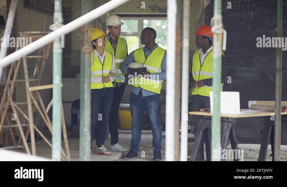 4K Construction team working together on site with foreman giving ...