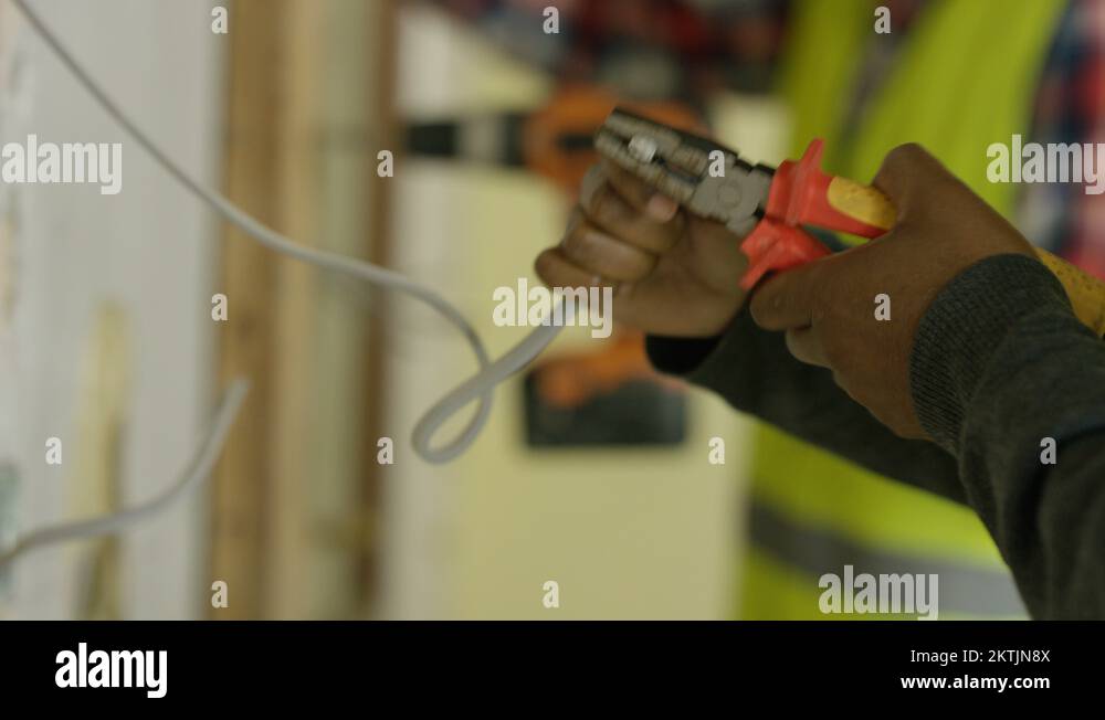 4K Construction workers on a building site drilling & checking wiring ...