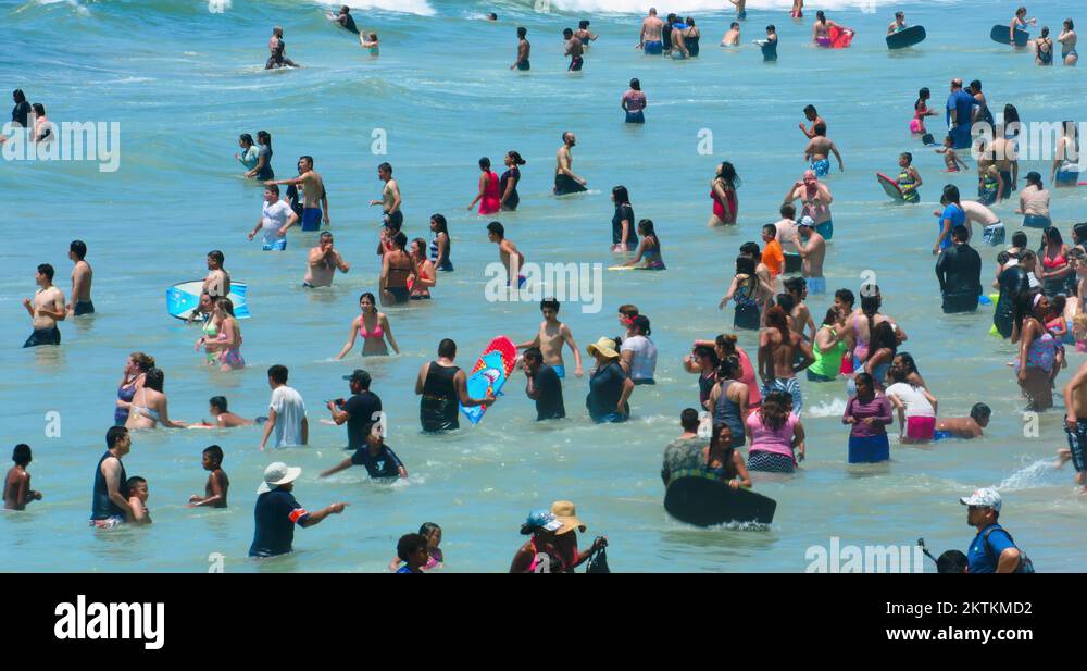 Crowd of people swim in the Pacific Ocean in Santa Monica Beach in LA ...
