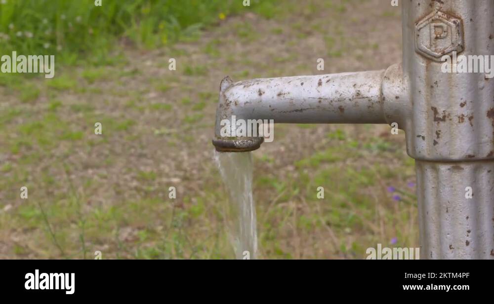 Irregular flow of water from the tap of a traditional water pump Stock ...