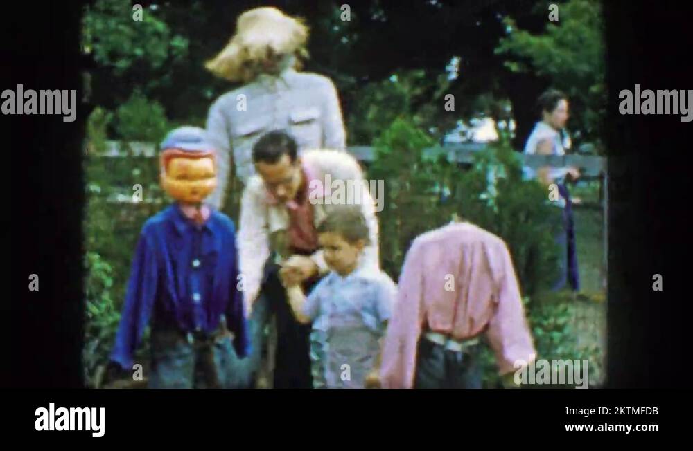 1957: Father son playing autumn festival headless scarecrow display ...
