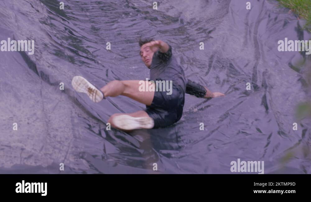 4K Portrait smiling mud race runners after slide down hill into cold ...