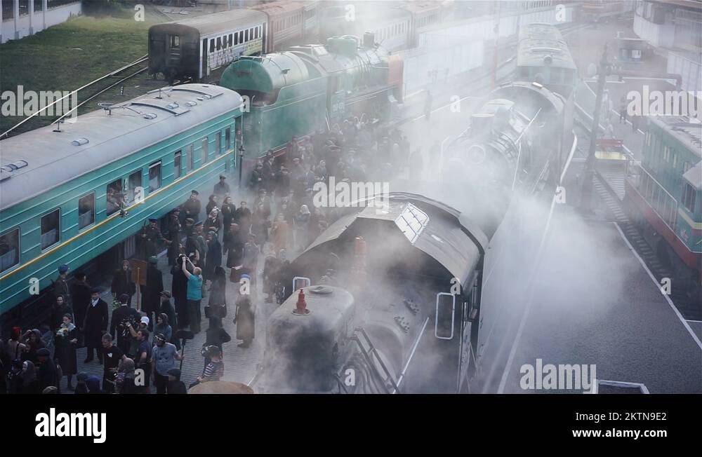 Cameraman, director, actors work at movie set, railway station with old ...