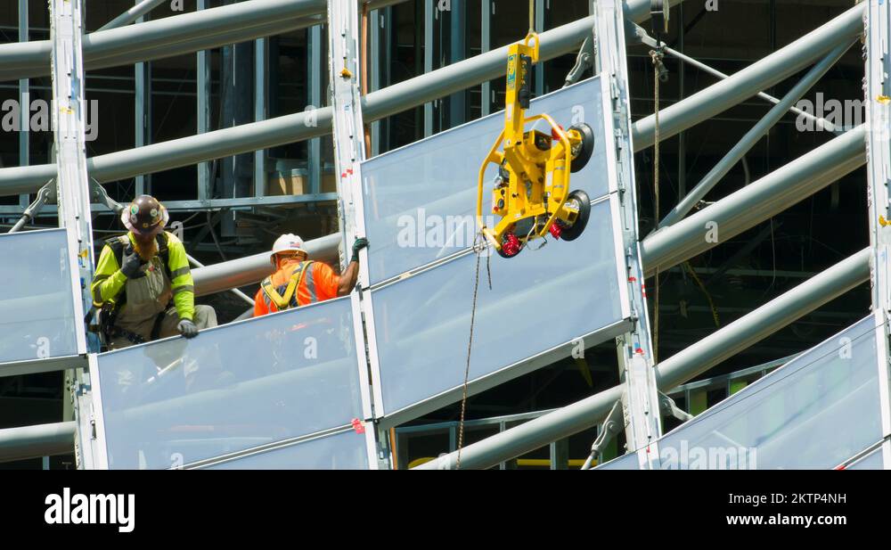 Construction workers install glass windows at development site in Los ...
