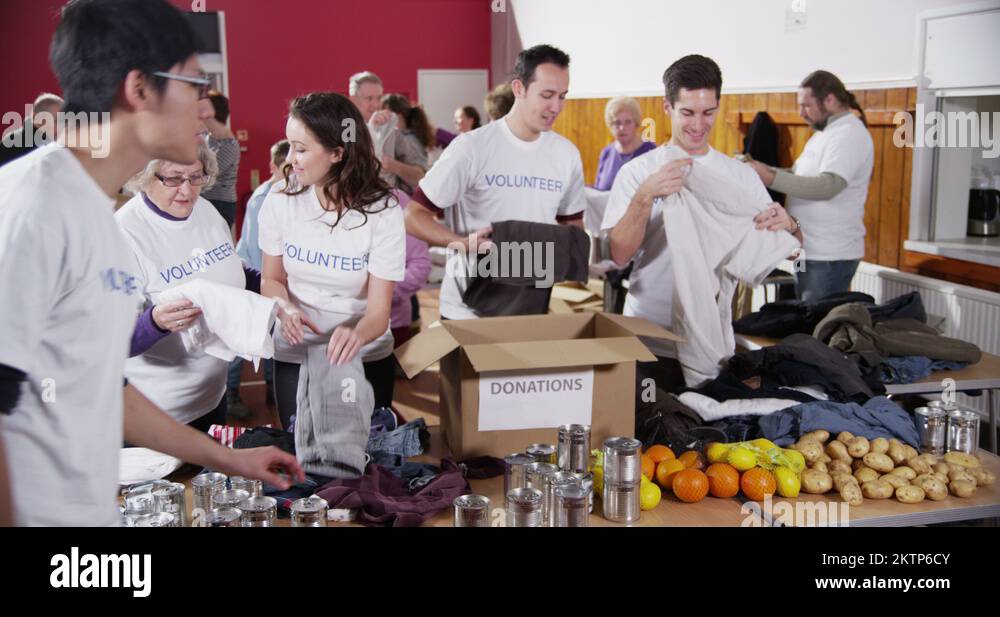 A mixed group of male and female charity workers are accepting donated ...