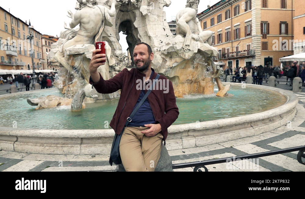 Man taking selfie photo by Fountain of the Four Rivers in Rome, Italy ...