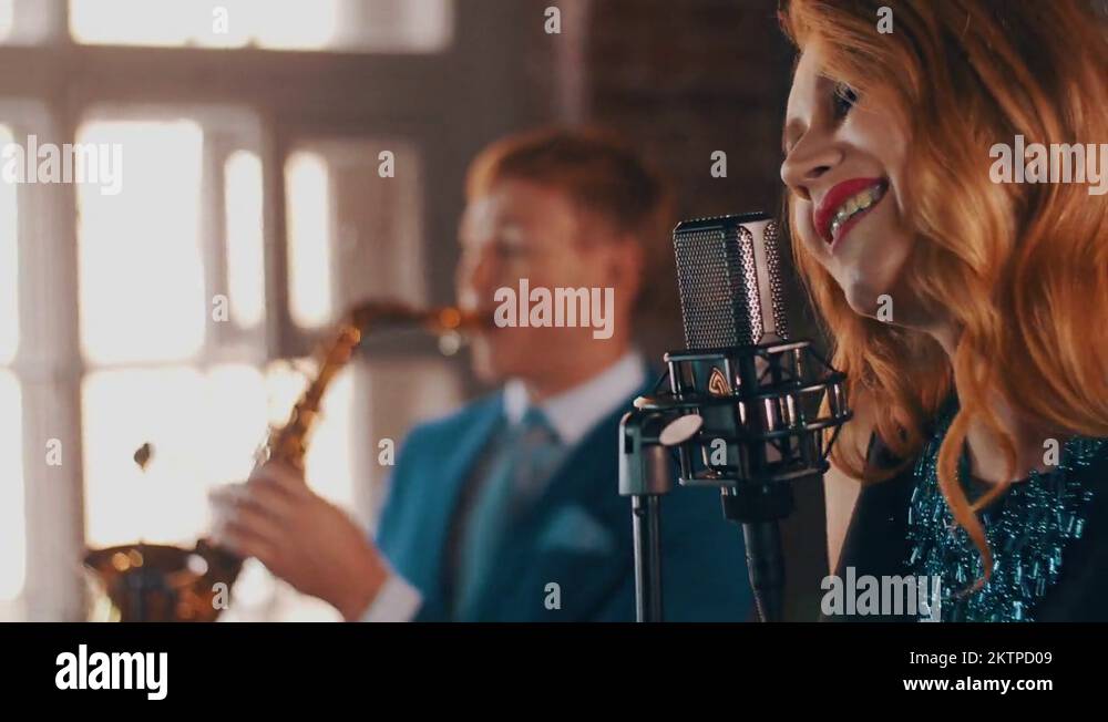 Attractive jazz vocalist performing on stage with saxophonist in blue ...