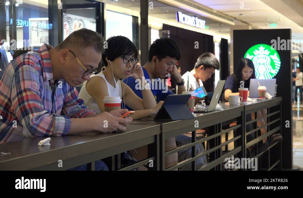 Chinese business people use smartphones at Starbucks coffee shop Stock ...