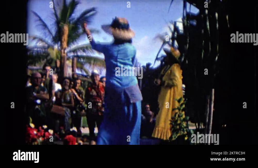 1968: a hawaiian scene where a lady dressed in blue is dancing for an ...