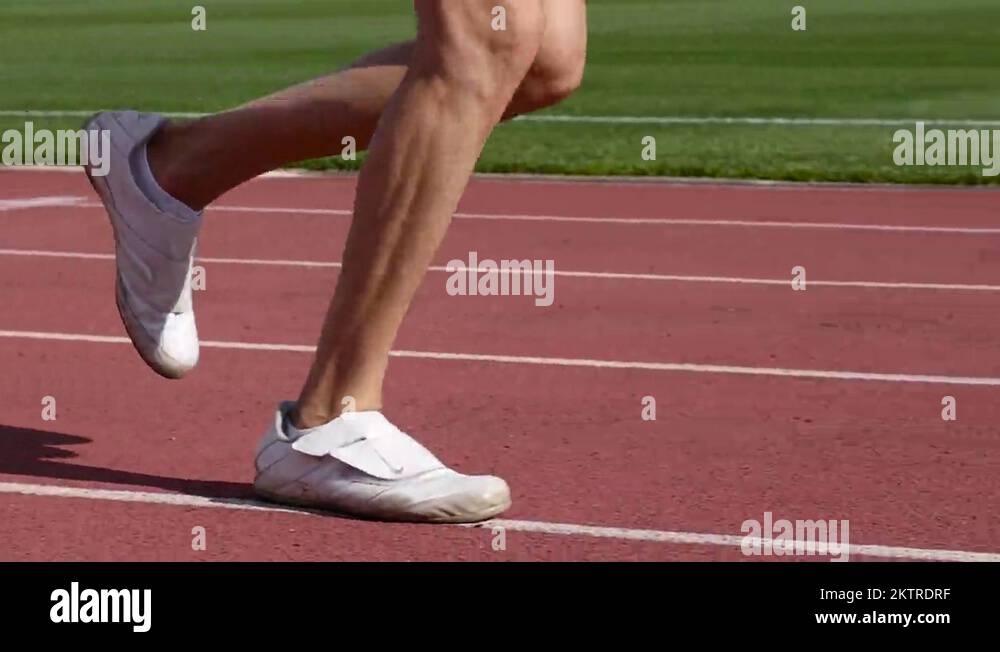 Strong healthy body legs man run on running stadium tracks during relay ...