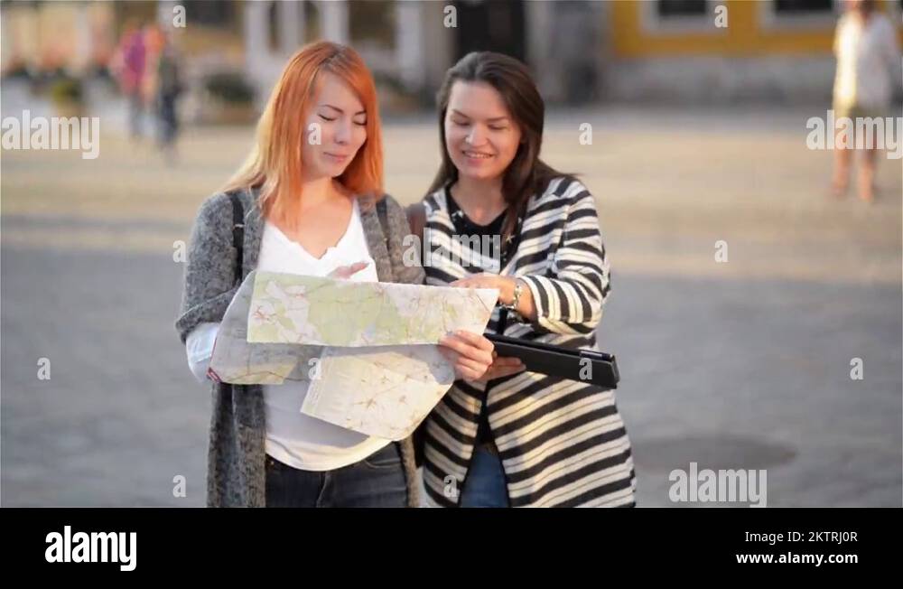 Two young girls on the streets of the old city. Girlfriends try to find ...