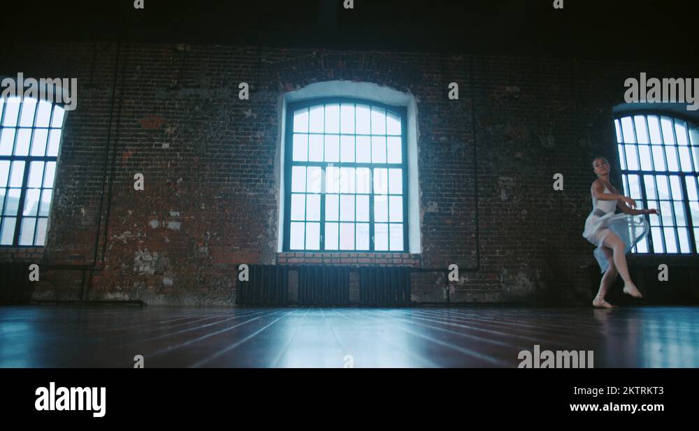 beautiful girl dancer performs a jump, and classical ballet in the loft ...