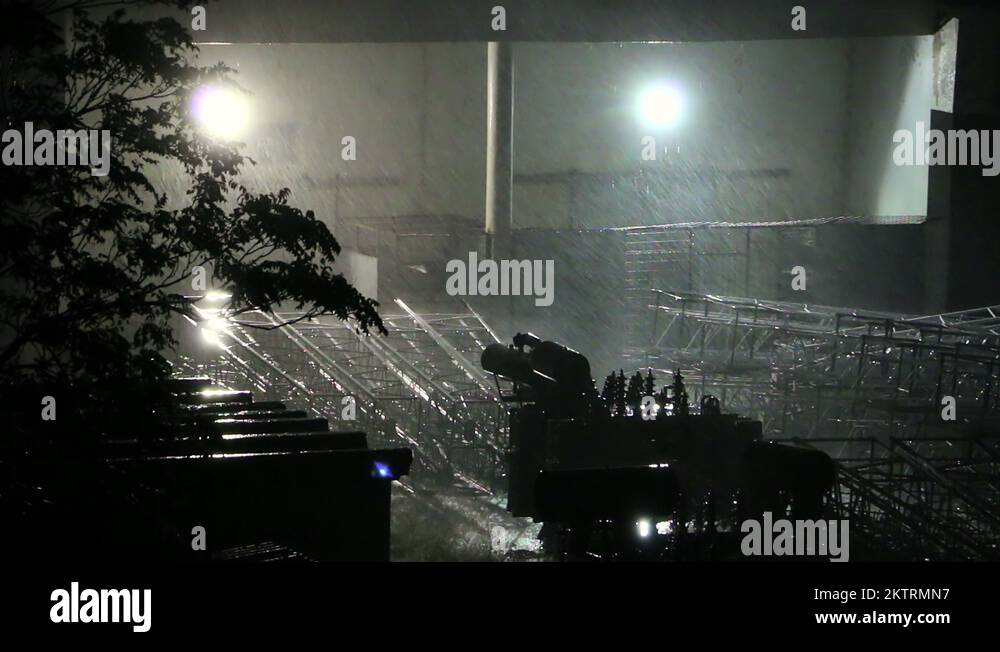 Stormy rain falling over construction site. Heavy rain falling at night ...
