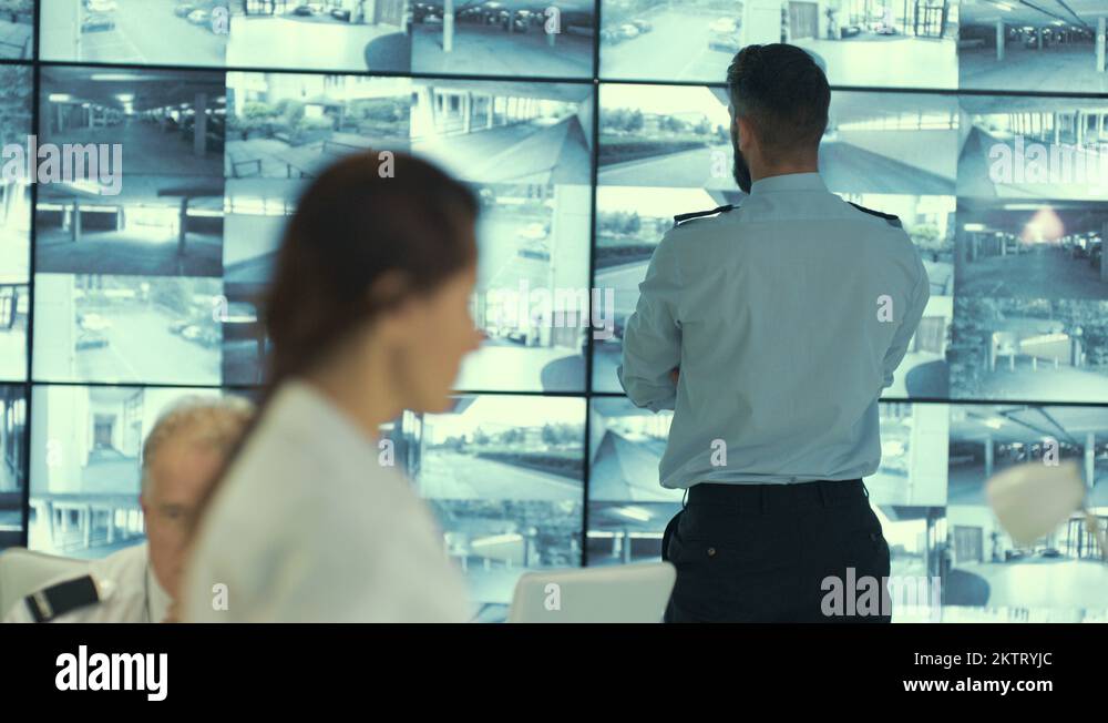 4K Security staff watching screens & discussing in observation control ...