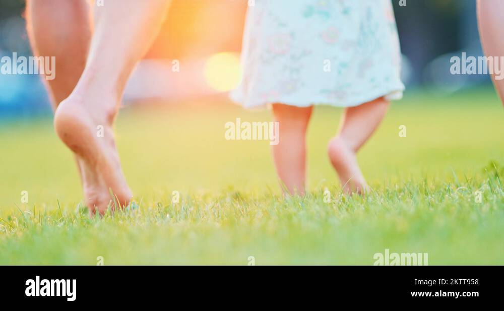 Little baby First Steps. Family feet walk on grass Close Up . SLOW ...