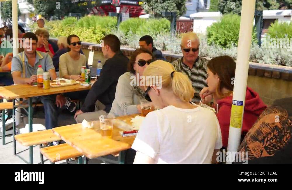 People relax eat and drink beer on a street food festival sitting at ...