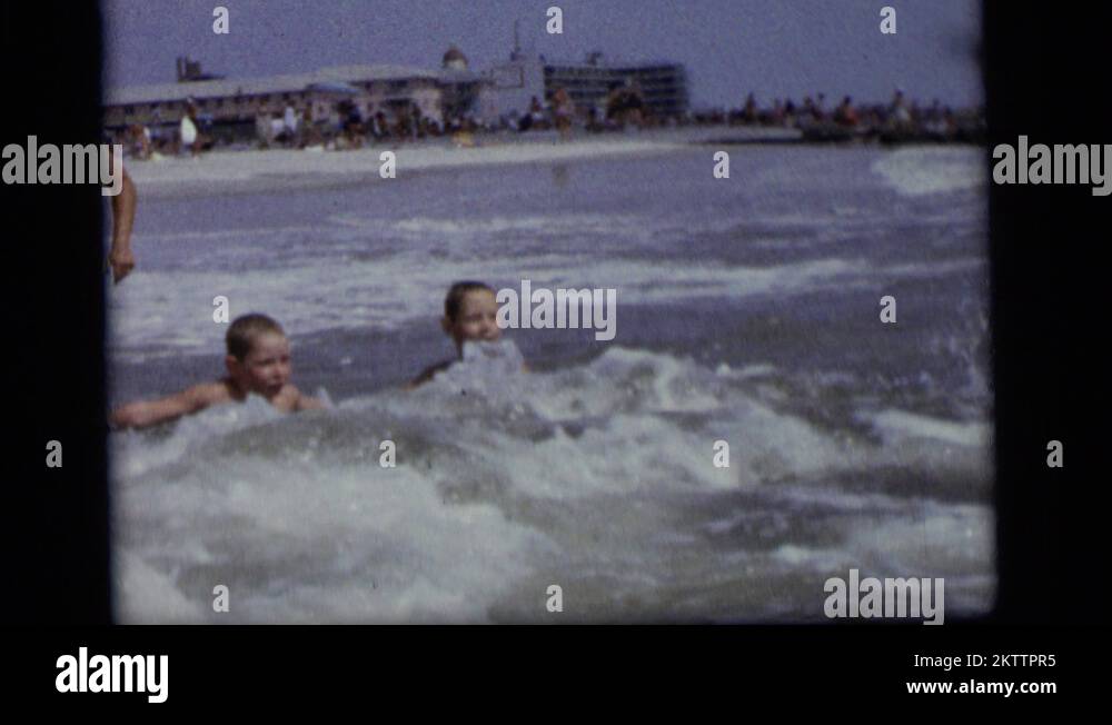 1964: two children taking pleasure of bathing in a sea beach with their ...
