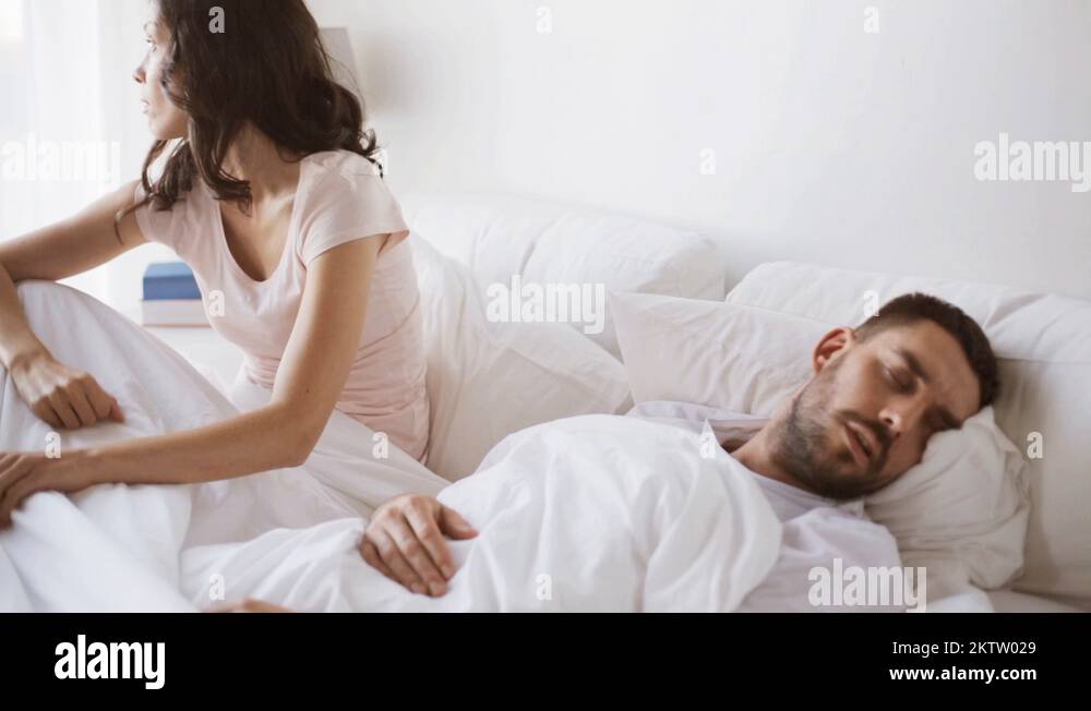 angry woman waking man sleeping in bed Stock Video Footage - Alamy