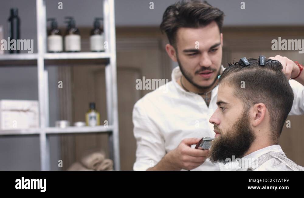 A man looks into a mirror after having his beard groomed at a barber ...