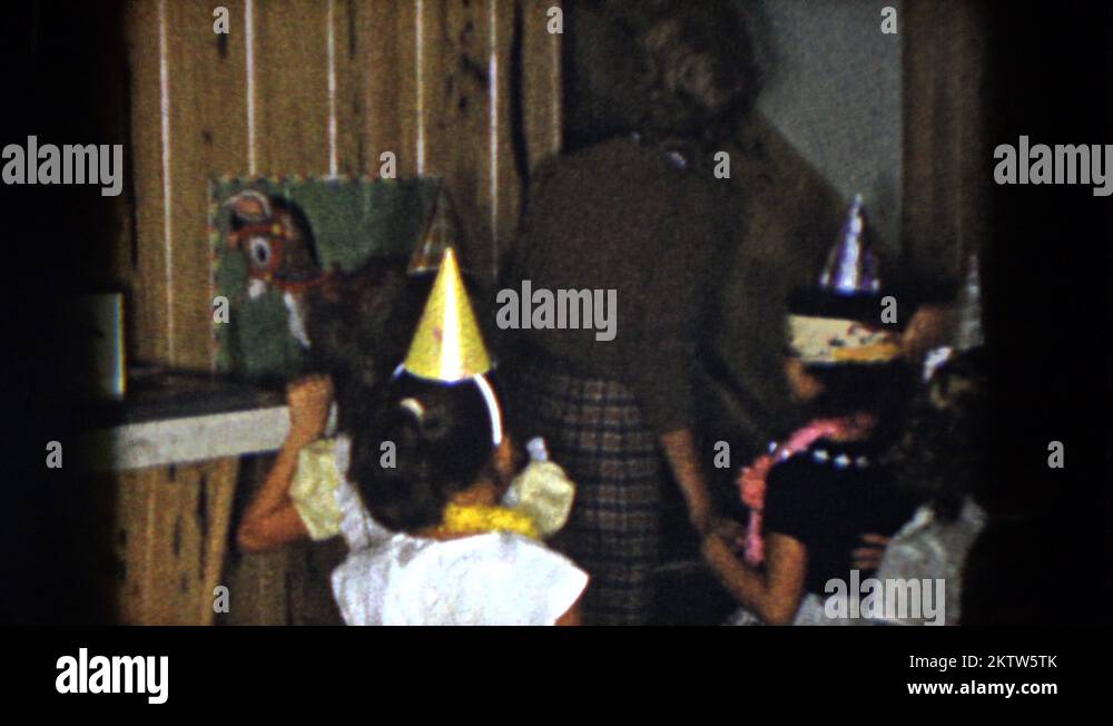 1961: several little girls wearing shiny birthday hats at a party ...