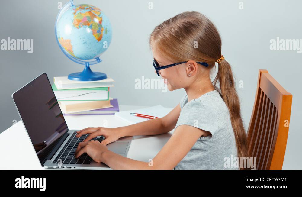 School girl four-eyes typing in her laptop and smiling at camera Stock ...