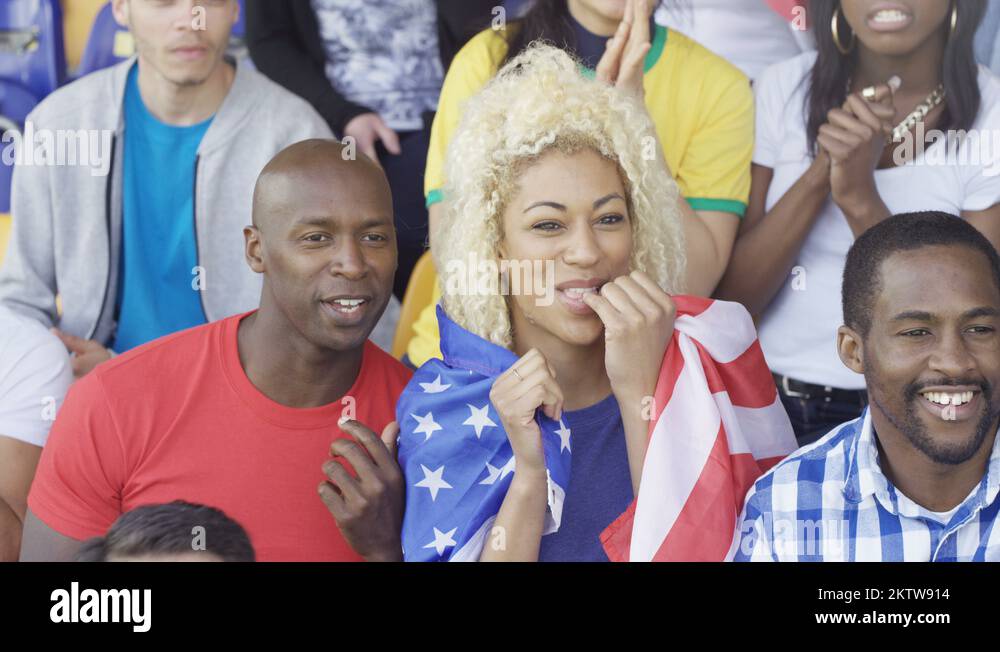 4K Crowd cheering on their team at sports event, woman holding US flag ...