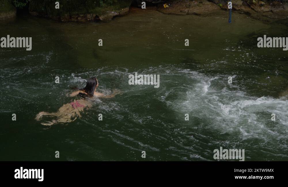 Woman swimming against the current in jungle river lagoon Stock Video ...