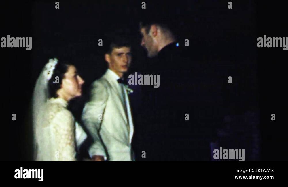 1964: a young newly married couple talking to a priest during the feast ...