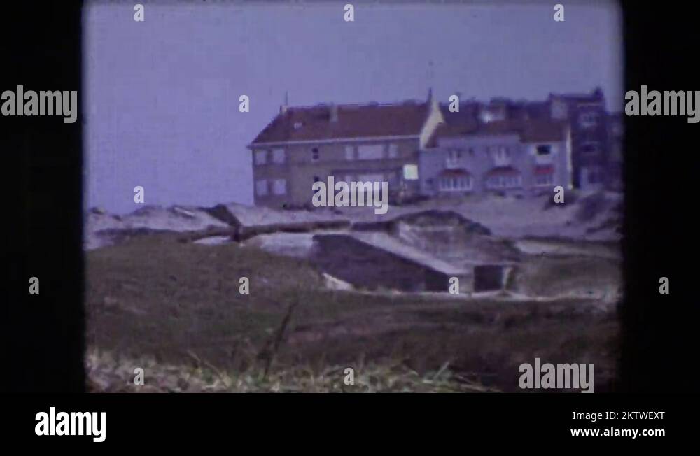 1967: large building on a hill grass in front stone structure with ...