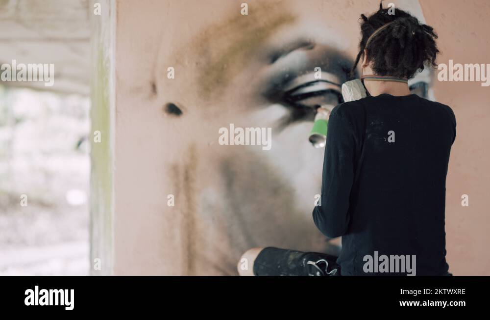 4K Masked graffiti artist using image on phone to copy portrait onto ...