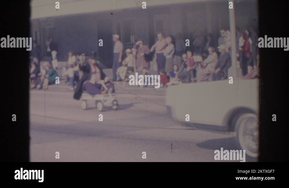 1966: two men wearing top hats sitting in little wagons being towed in ...