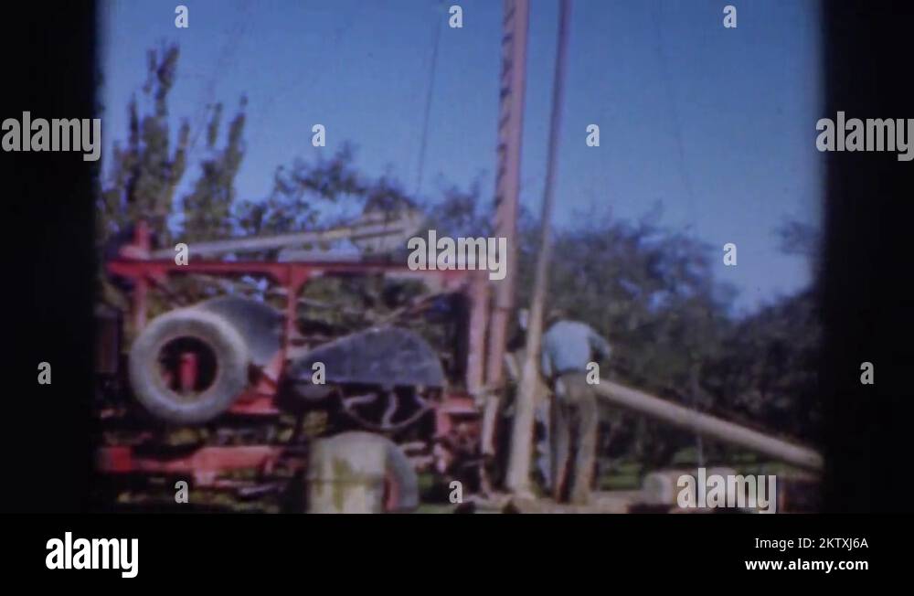 1937: people work to build a structure with a very tall mast with ropes ...