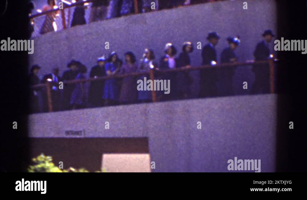 1939: a large group of people walking in a row by a helical ramp of a ...