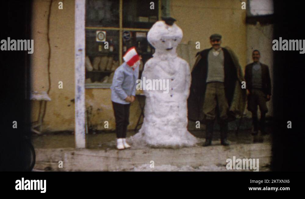1958: couple poses beside a seven foot tall snowman on the front porch ...