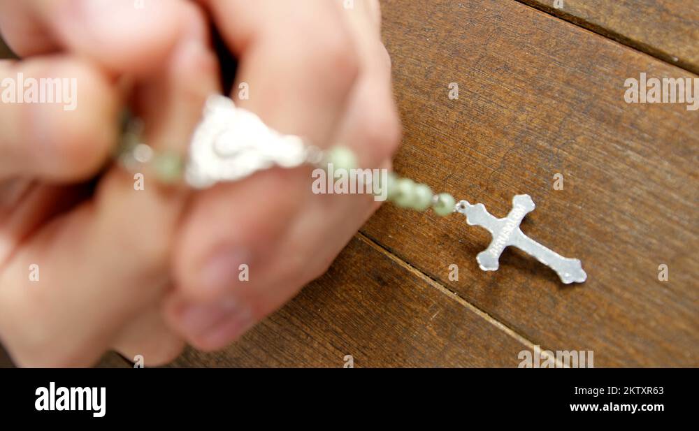 Praying hands holding rosary Stock Video Footage - Alamy