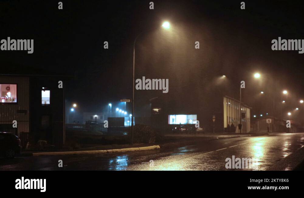 People walking under street lights in heavy rain storm wind small town ...